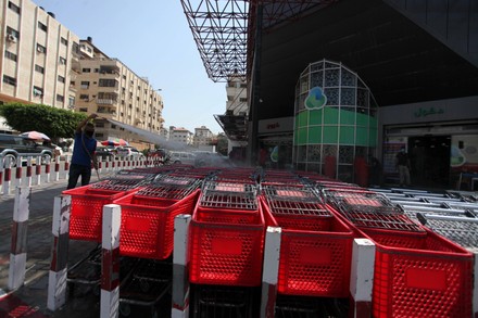 __COUNT__ A Palestinian man, wearing protective gear, disinfects ...