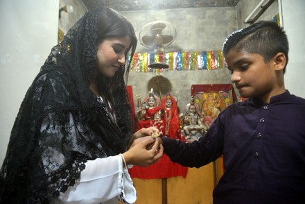 Hindu performs religious rituals after tying Rakhi (sacred thread) on ...