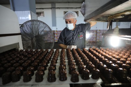 Palestinian workers prepare the vanilla candy known as "Ras El-abed or ...