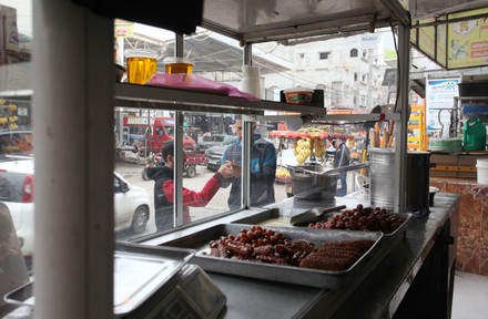 Palestinian vendor prepares traditional sweet called "awwamah" during ...