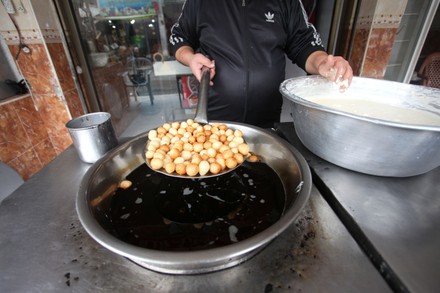 Palestinian vendor prepares traditional sweet called "awwamah" during ...