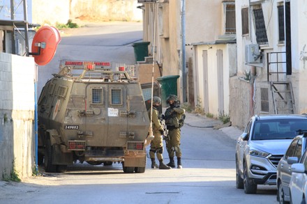 Israeli forces take position during a raid in the town of Rummanah ...