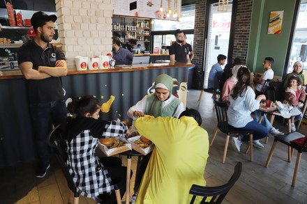 Palestinian customers eat Italian pizza and burger at a restaurant ...