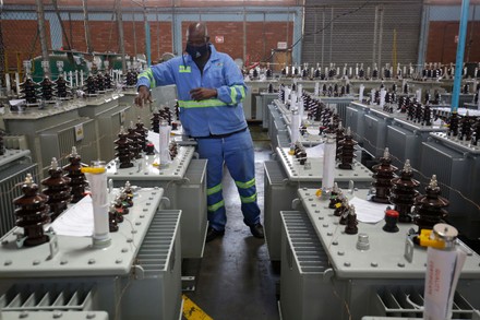 Employees work on electricity transformers at an assembly plant in ...