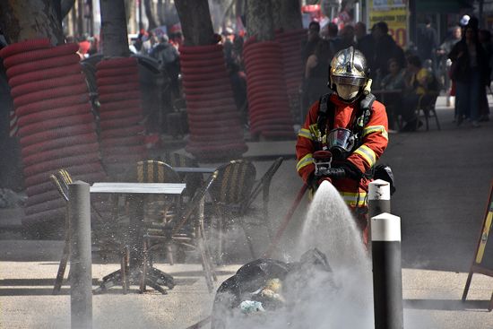 Firefighter Puts Out Trash Fire During Editorial Stock Photo - Stock ...