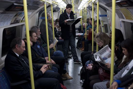 Commuter Reads Newspaper On Train Tube Editorial Stock Photo - Stock ...