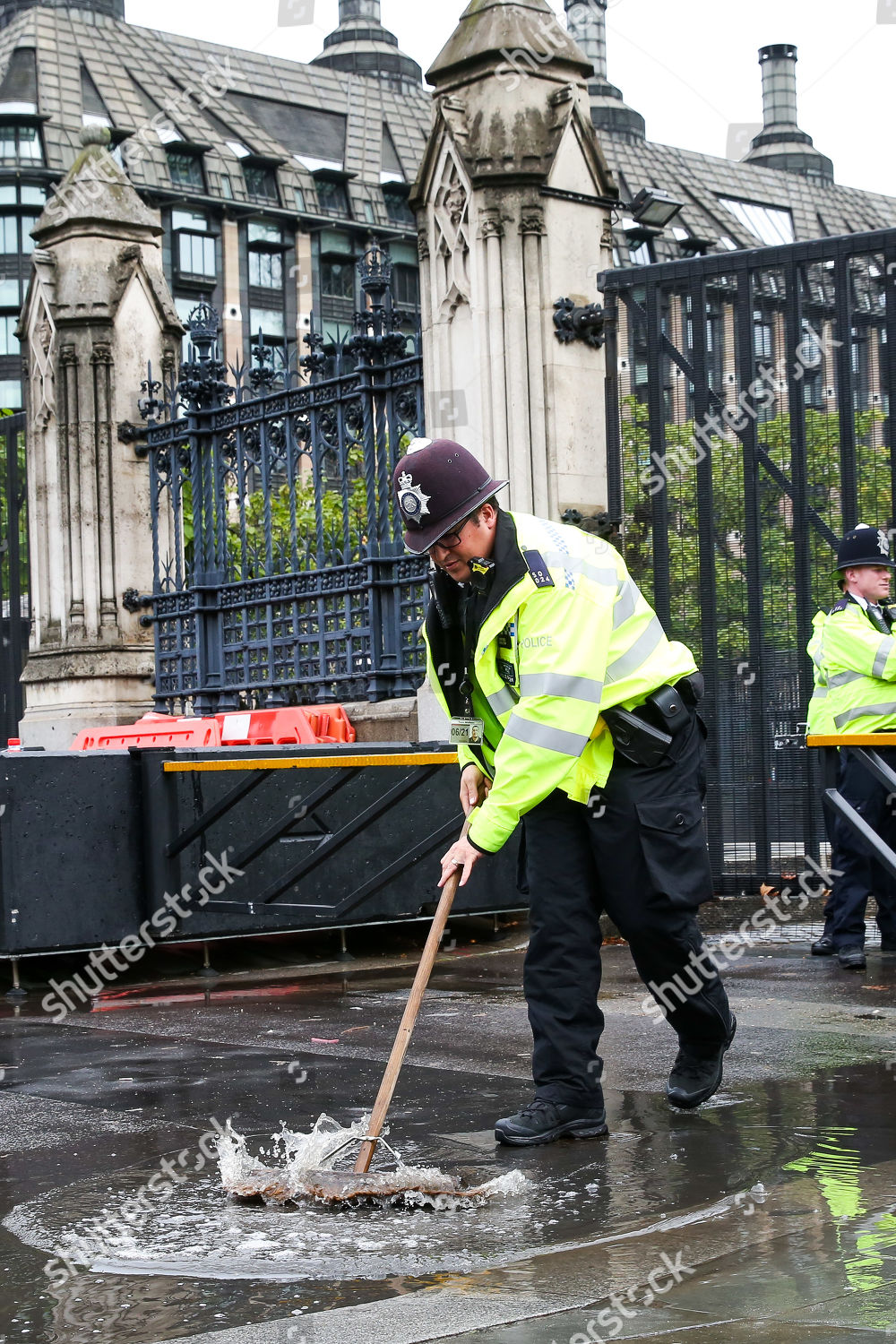 POLICE OFFICER SWEEPS AWAY PUDDLE RAIN Editorial Stock Photo - Stock ...