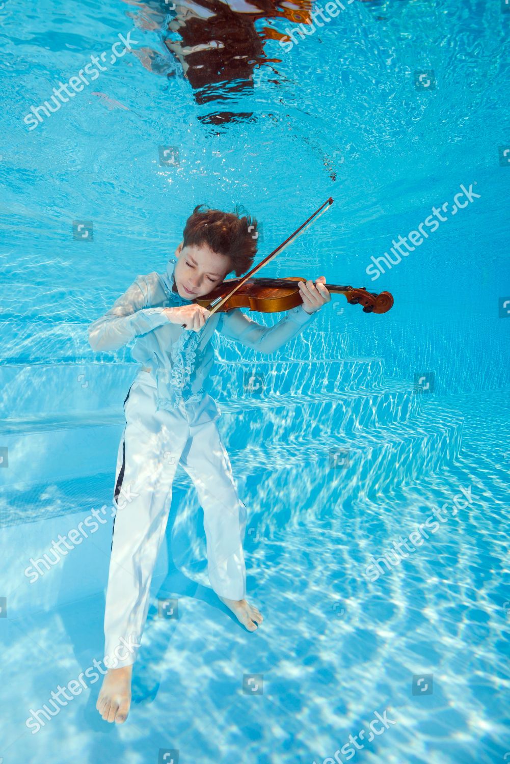 Model Released Boy Playing Violin Underwater Editorial Stock Photo model-released-boy-playing-violin-underwater-editorial-stock-photo